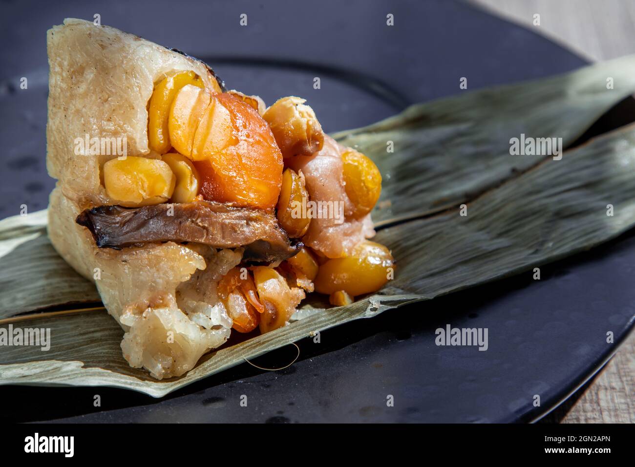 Chinese rice dumpling (Zongzi) shaped pyramidal wrapped by leaves ...