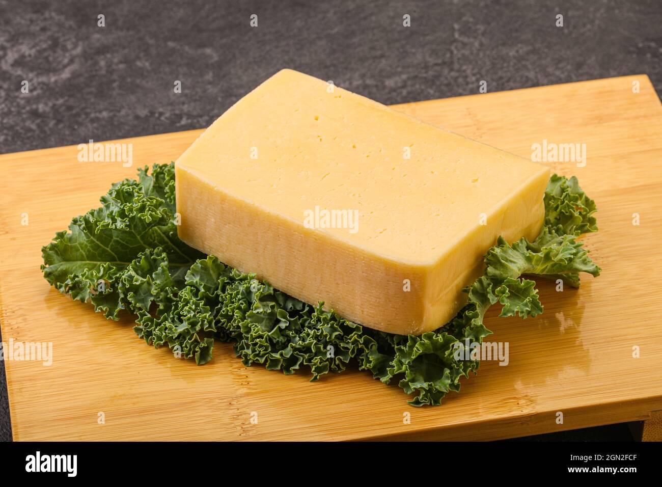 Tasty yelloow Tilsiter cheese brick over board Stock Photo - Alamy