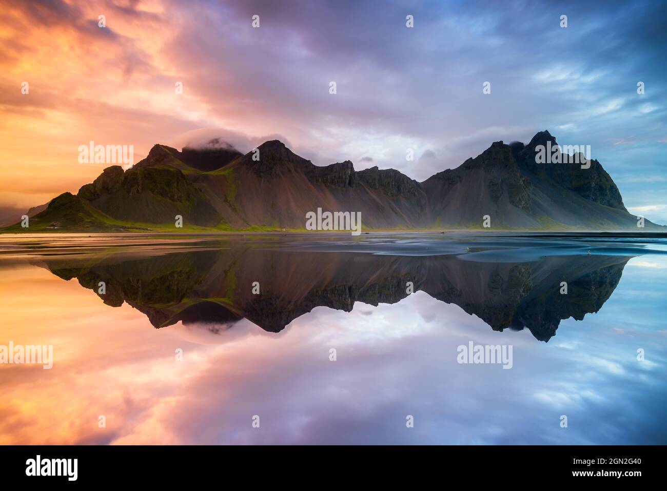 ICELAND, VESTRAHORN, VESTRAHORN MOUNTAIN AT SUNRISE WITH ITS REFLECTION FROM STOKKSNES BEACH ...