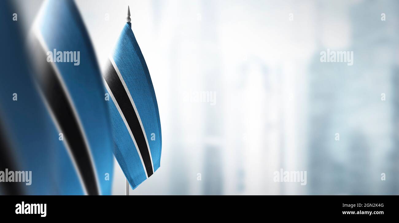 Small flags of Botswana on a blurry background of the city Stock Photo ...