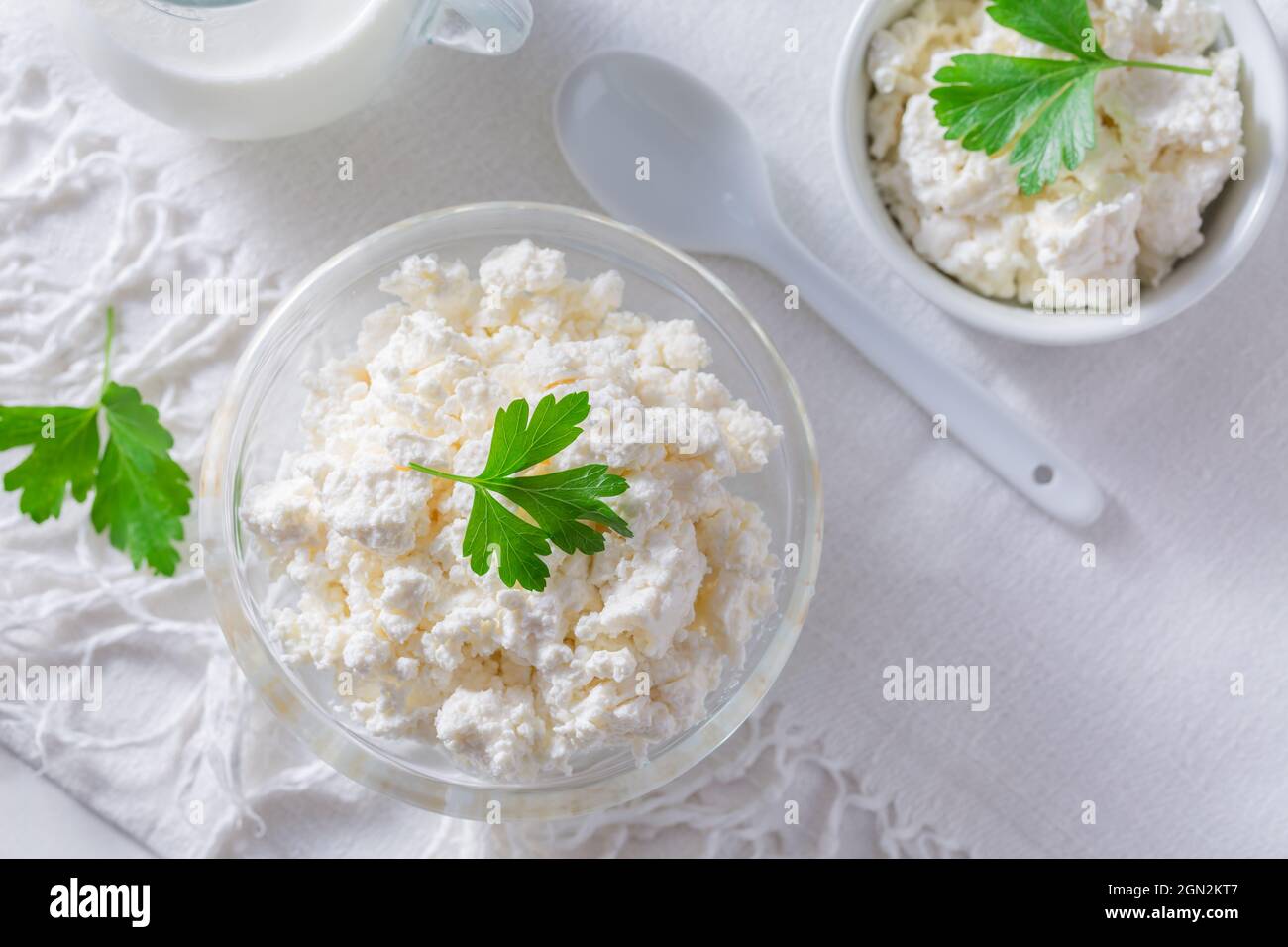 Dairy product - curd or cottage cheese, quark in bowl and milk on white ...