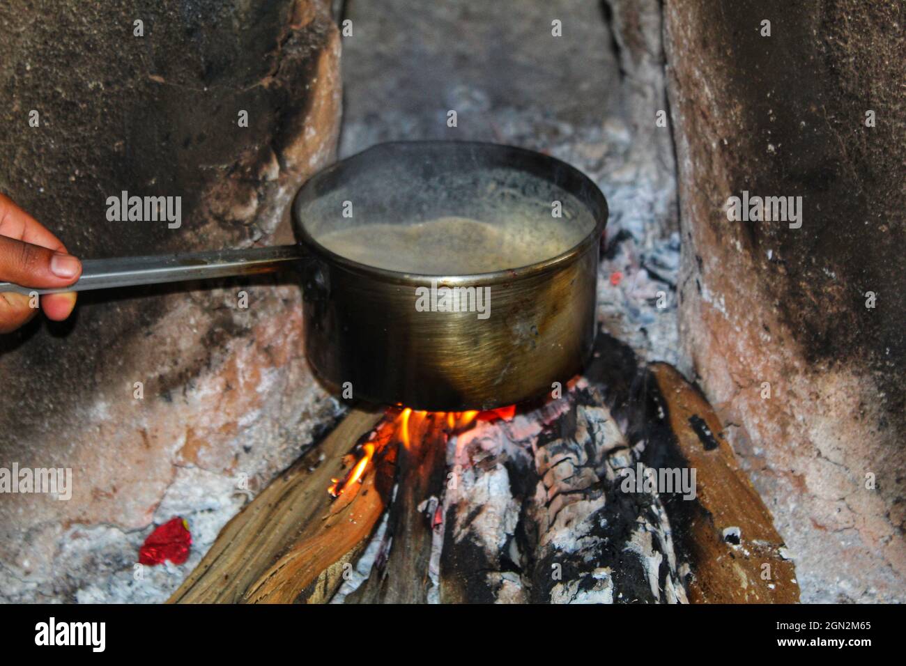 Person boiling food in a pan on a bonfire Stock Photo - Alamy