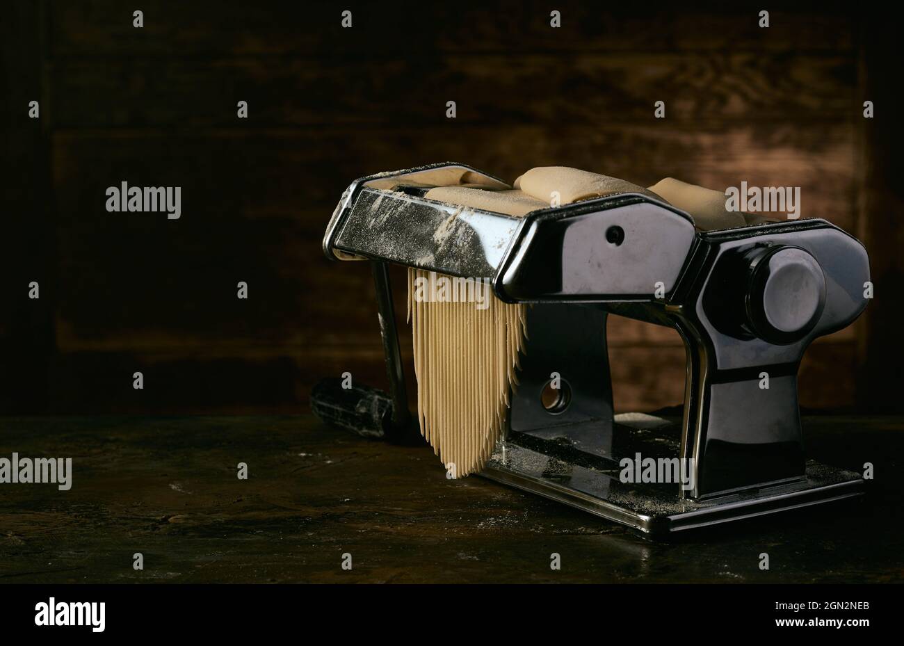 Modern steel machine for making spaghetti from raw pastry placed on ...