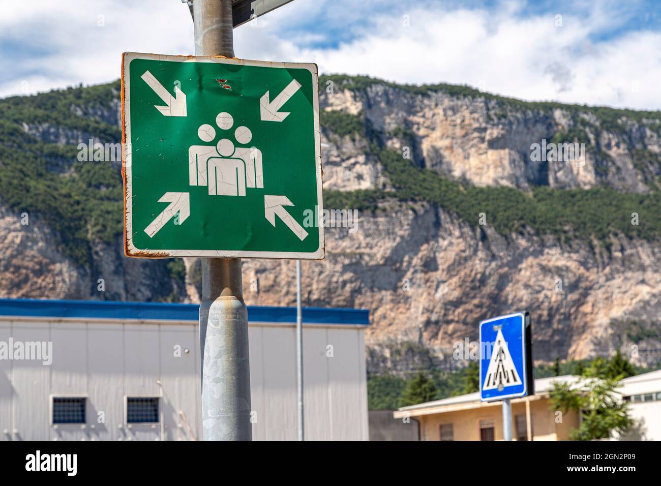 Signpost with icons showing a collection point for people in case of a ...