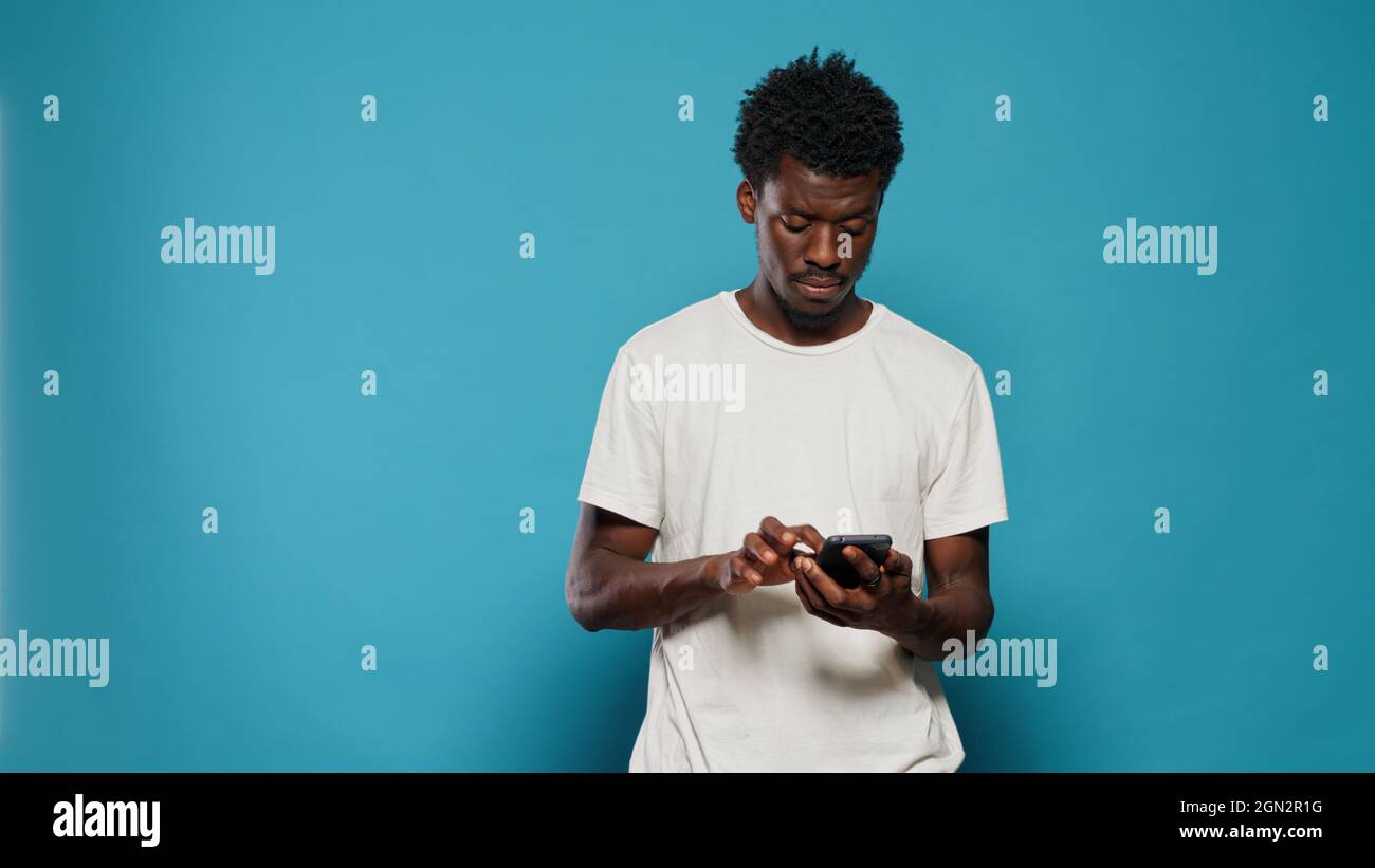 Confused man using smartphone for text messages and browsing internet ...