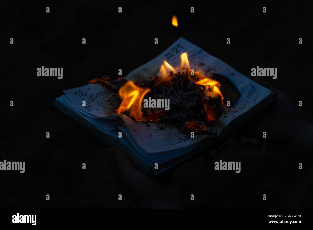 Open burning diary on black background. Notebook with flame cove Stock ...