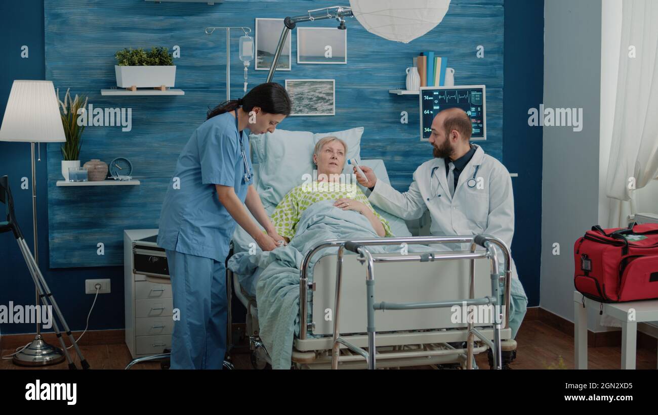 Old woman with sickness getting consultation from nurse and doctor in ...