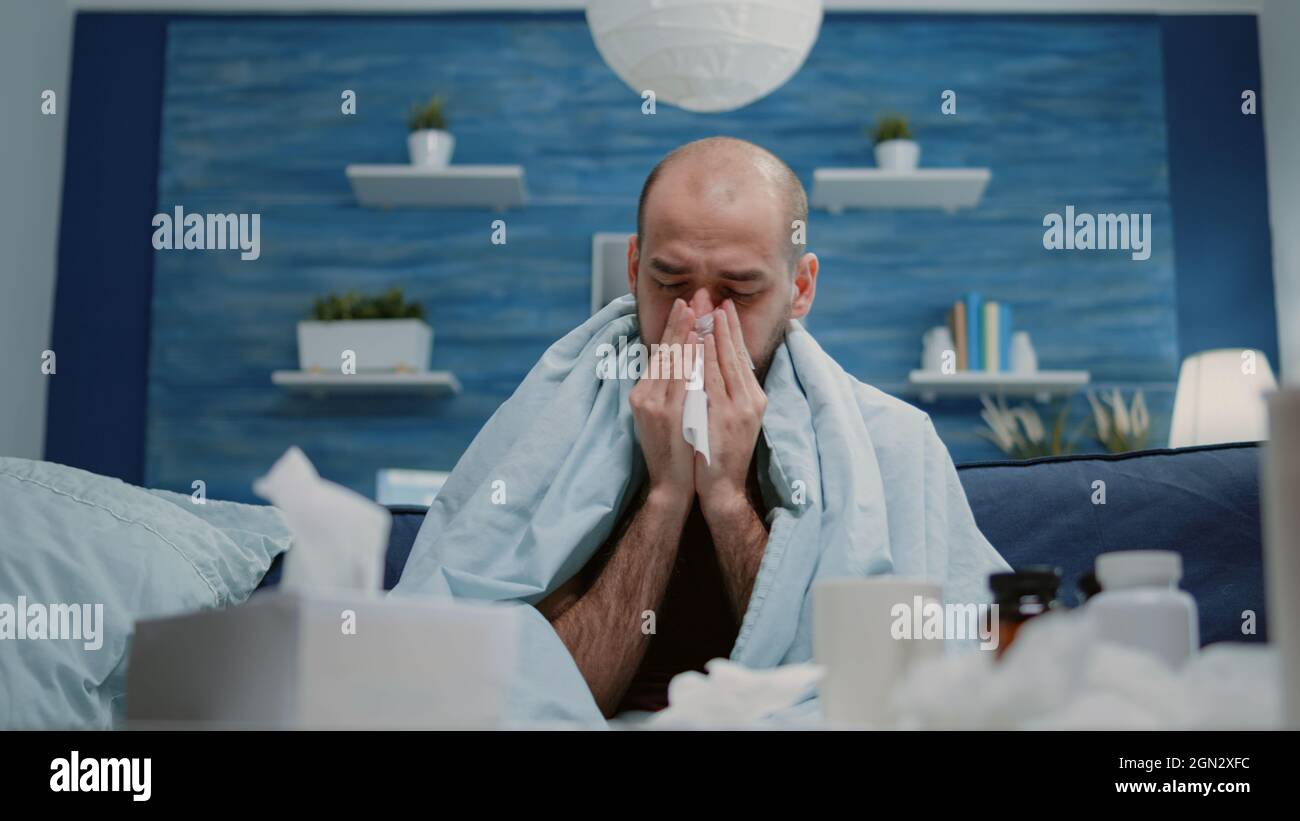 Close up of man with cold and flu blowing runny nose using tissue. Sick ...