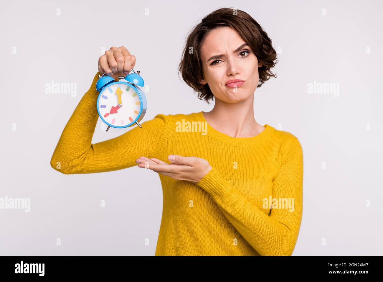 Photo of sad brunette millennial lady hold clock wear yellow shirt ...