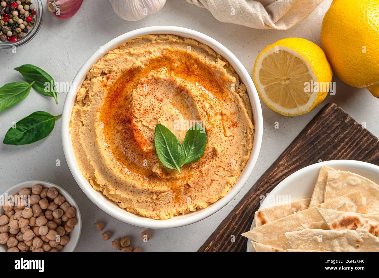 Hummus and ingredients on a gray background, close-up. A useful ...