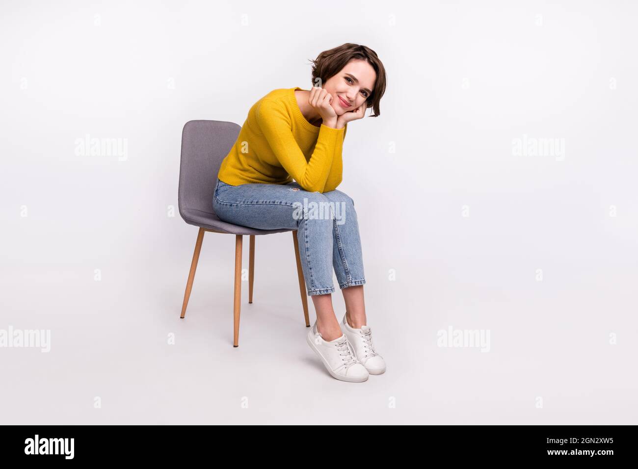 Photo of adorable positive cheerful nice girl hands cheeks sit chair ...