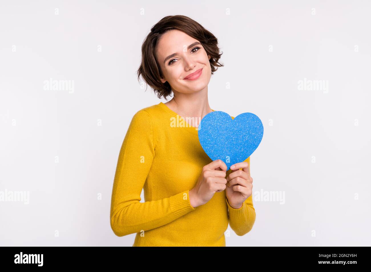 Photo of cute brunette millennial lady hold heart wear yellow shirt ...