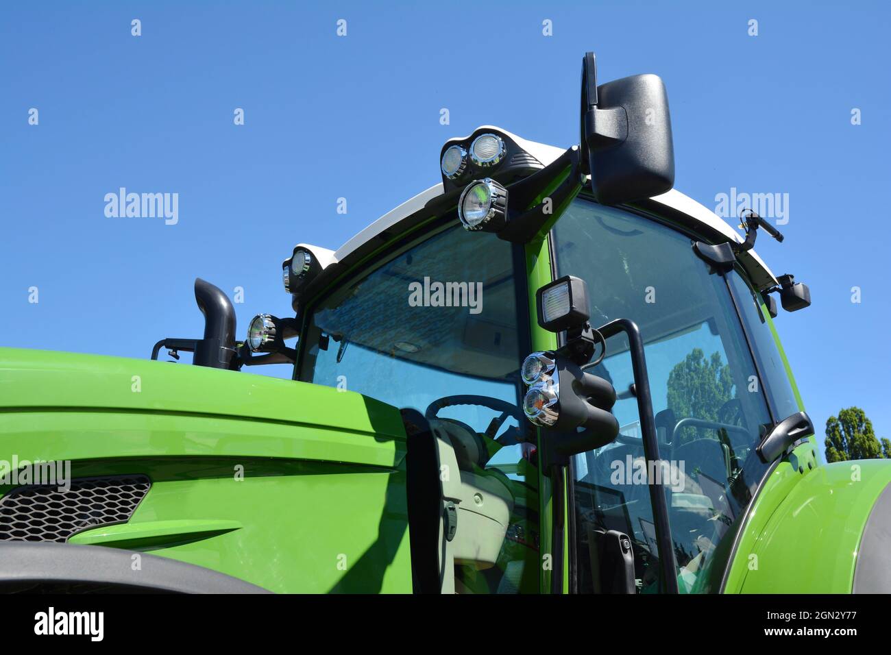 Modern tractor cabin. New green tractor with headlights Stock Photo - Alamy