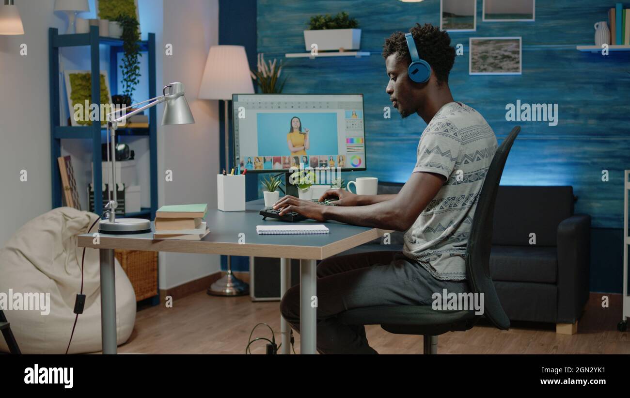 Photography editor with headphones working with retouch app to edit ...