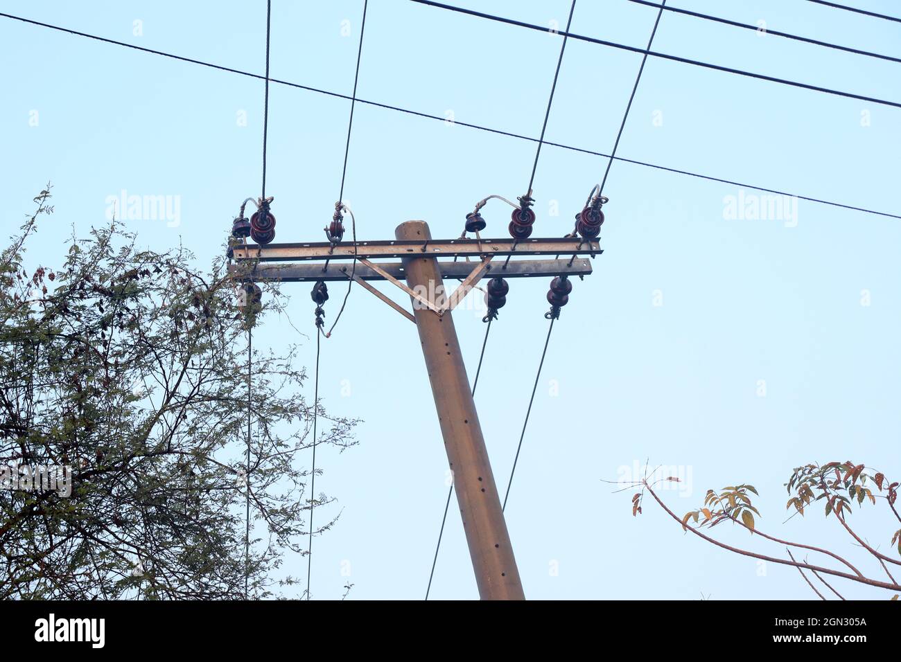 high voltage electric pillar closeup on green field for current supply ...