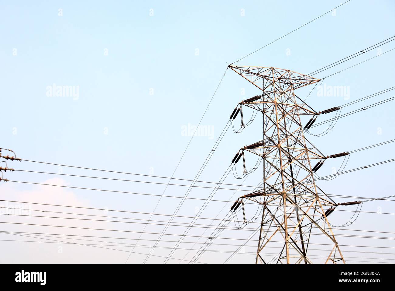 high voltage electric pillar closeup on green field for current supply ...