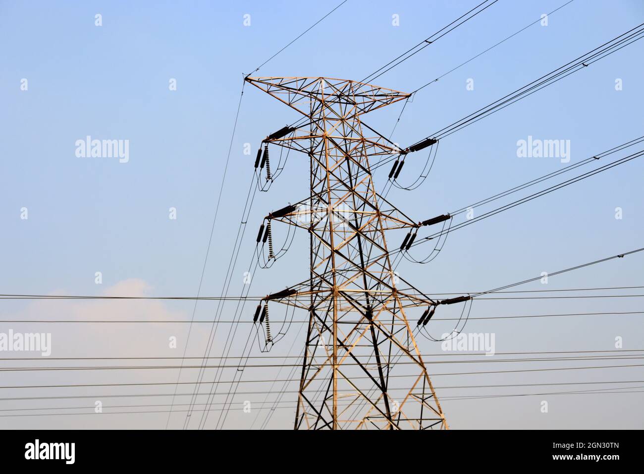 high voltage electric pillar closeup on green field for current supply ...