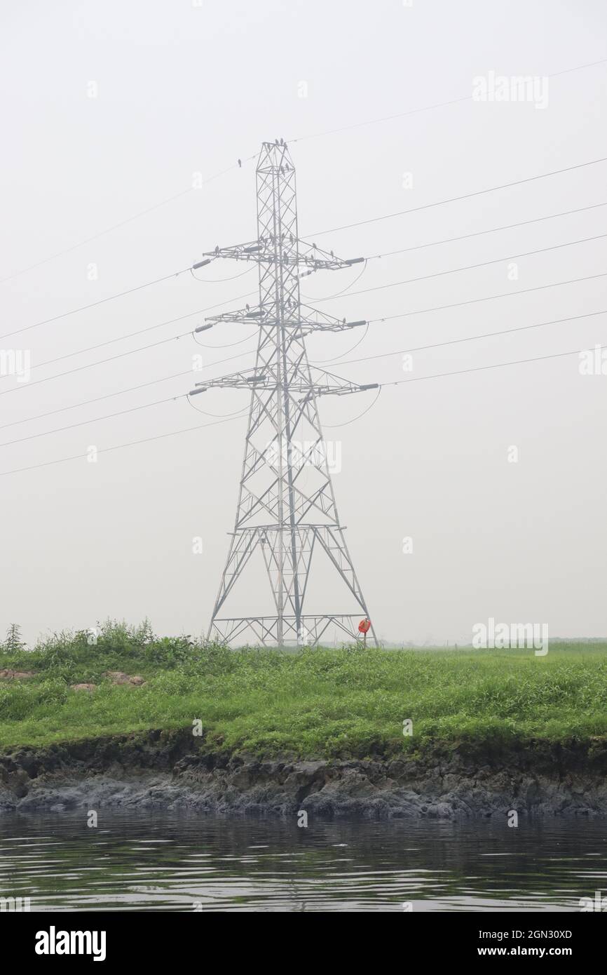 high voltage electric pillar closeup on green field for current supply ...