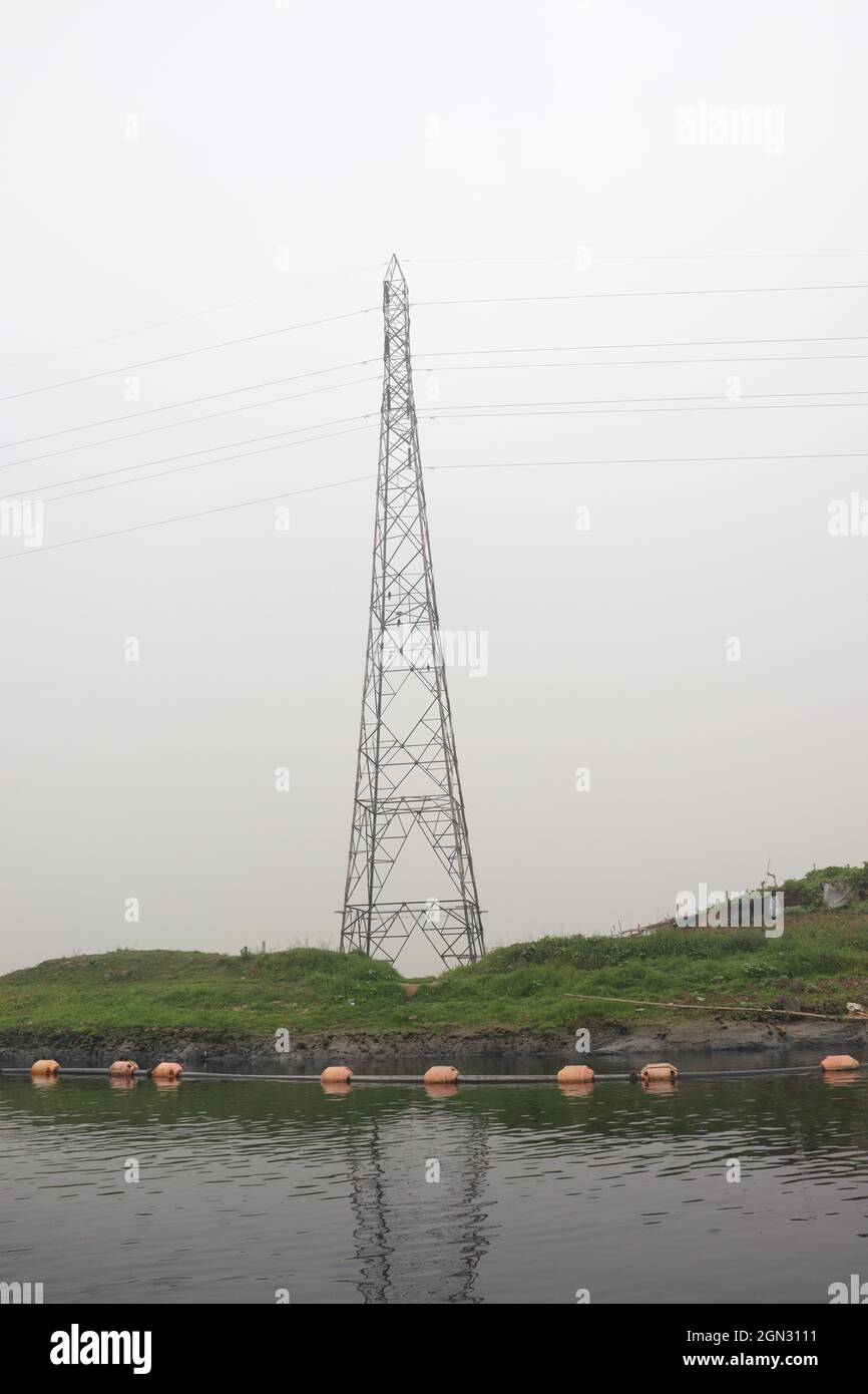 high voltage electric pillar closeup on green field for current supply ...