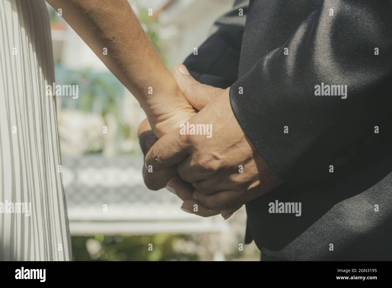 Two people holding hands Stock Photo - Alamy