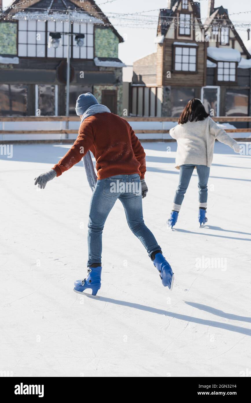 back view of young couple skating on ice rink Stock Photo - Alamy