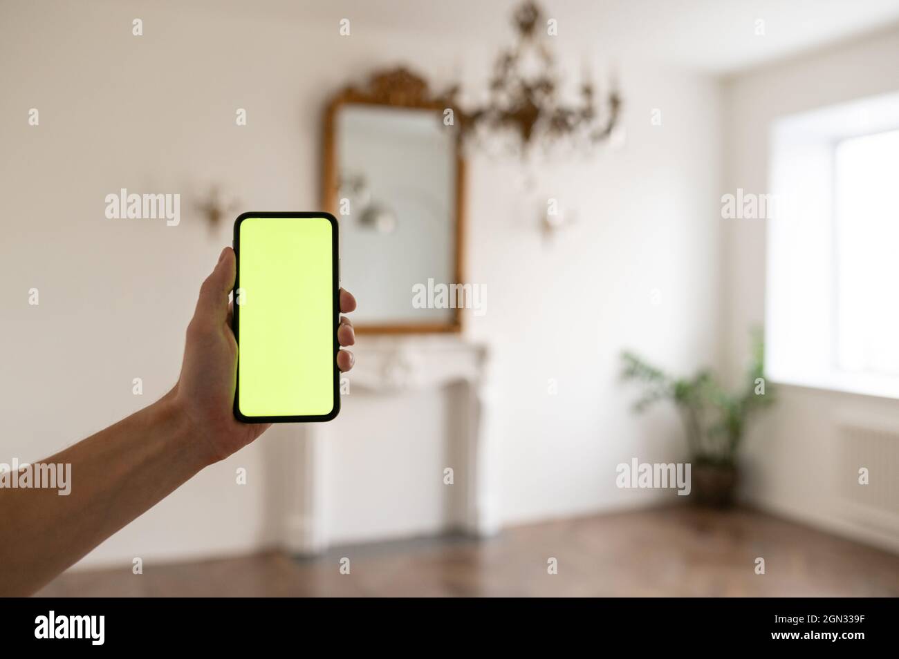 Man at Home Lying on a Couch using Smartphone with Green Mock-up Screen, Doing Swiping. Guy ...