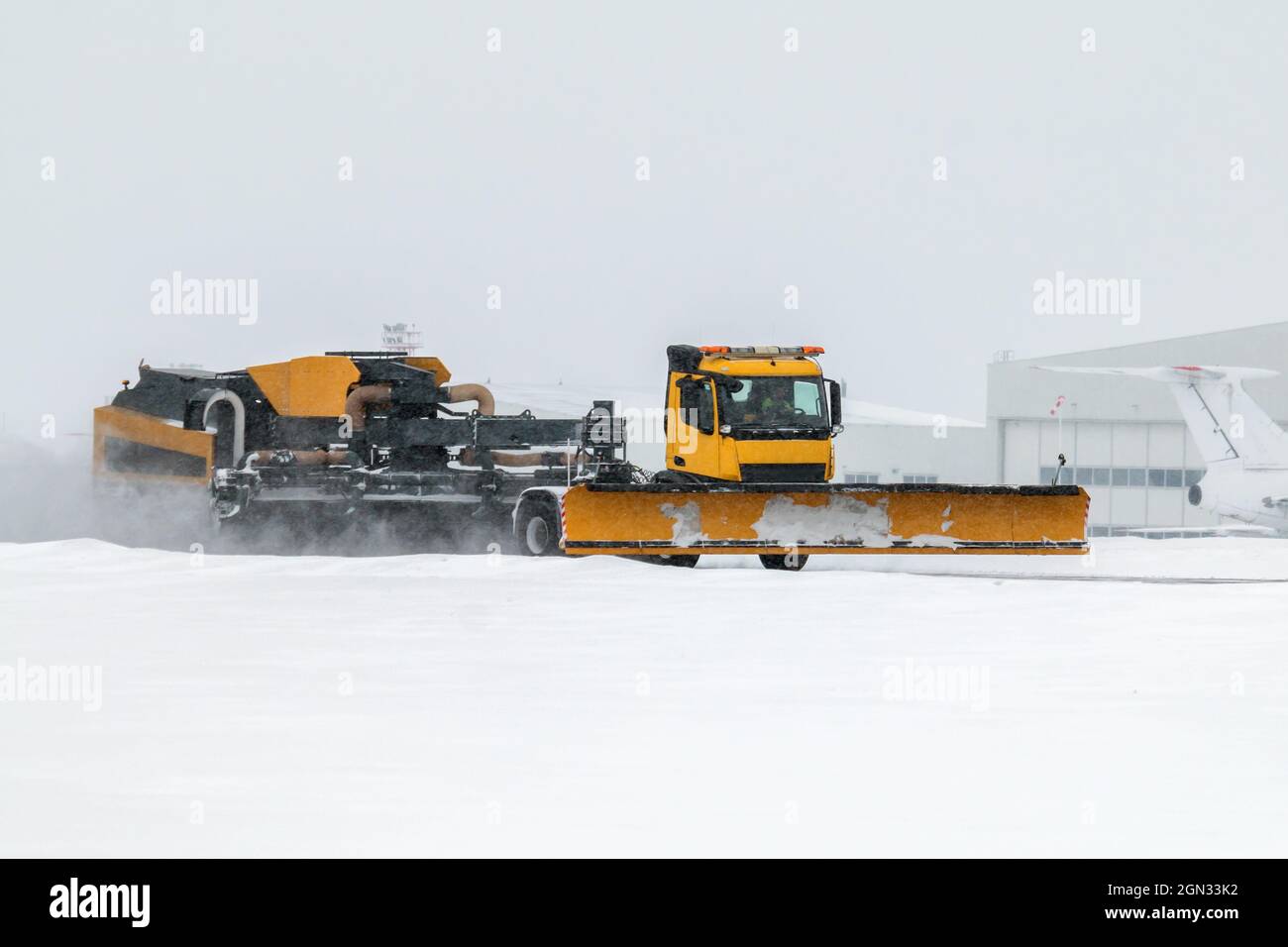 Airfield snow blowers cleaning the area near the airplane hangar at the ...