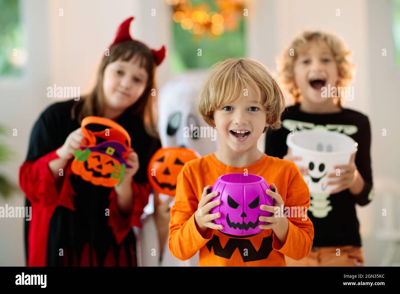 Kids trick or treat in Halloween costume. Children in colorful dress up ...