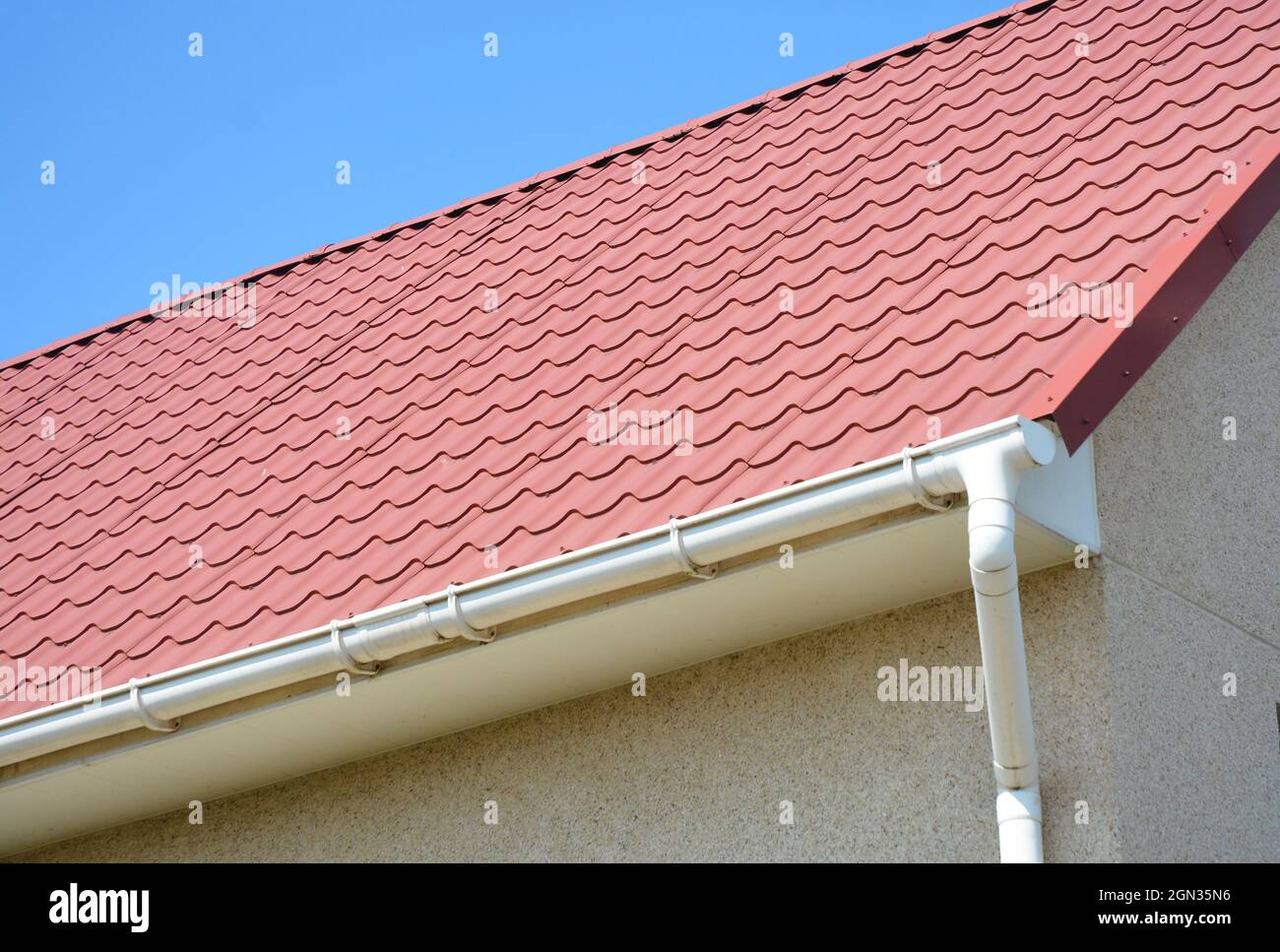 Roof gutter with house red metal tiled roof Stock Photo - Alamy