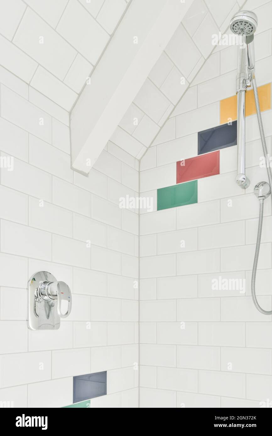 Shower room with stainless steel tap and colorful tiles in attic of ...