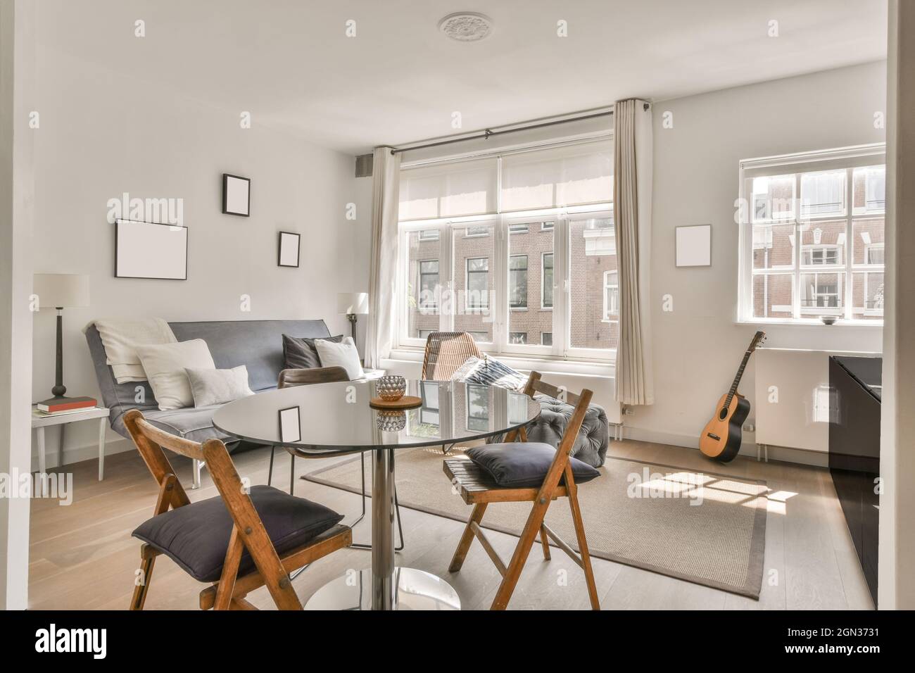Interior of light living room with comfortable sofa and round glass ...