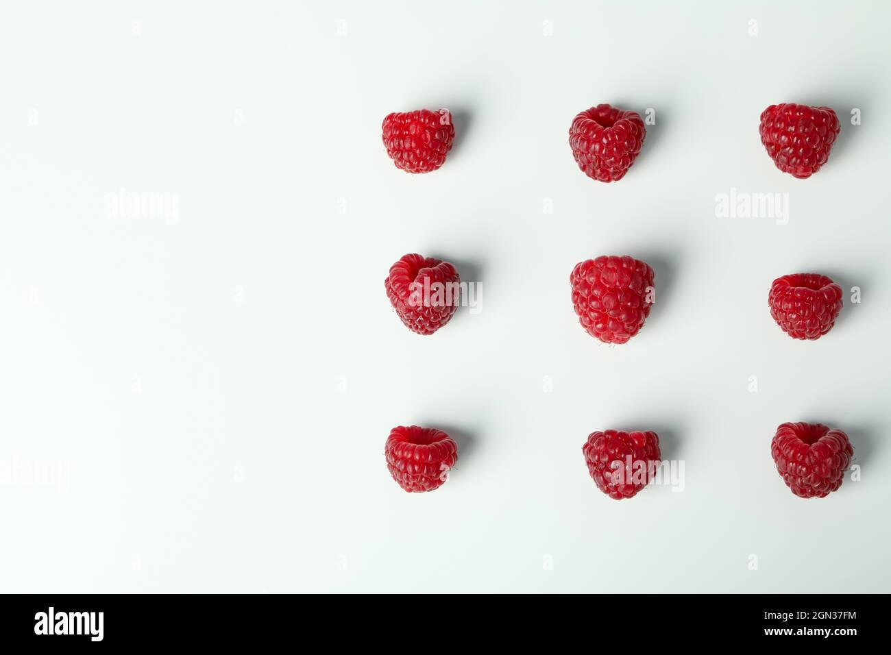 Flat lay composition with red juicy raspberries on a white background ...