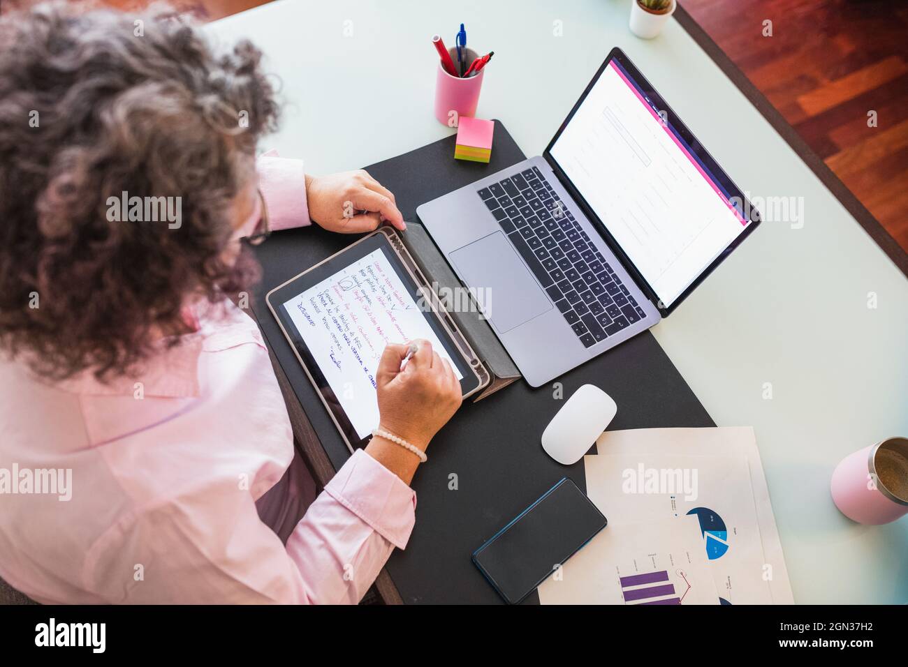 From above of crop anonymous female entrepreneur with tablet and ...