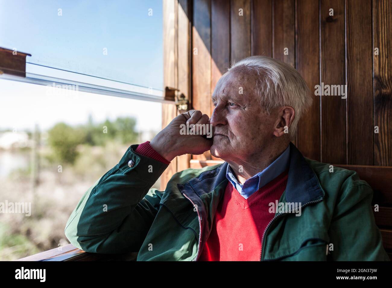 Side view of attractive man and old man traveling in an old wooden ...