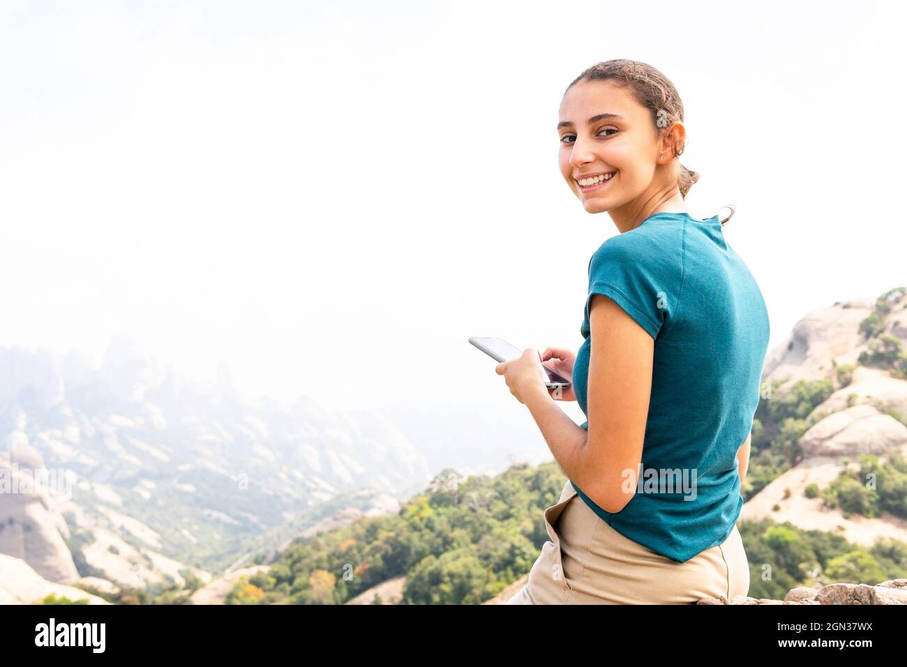 Side view of positive female tourist texting on cellphone during ...