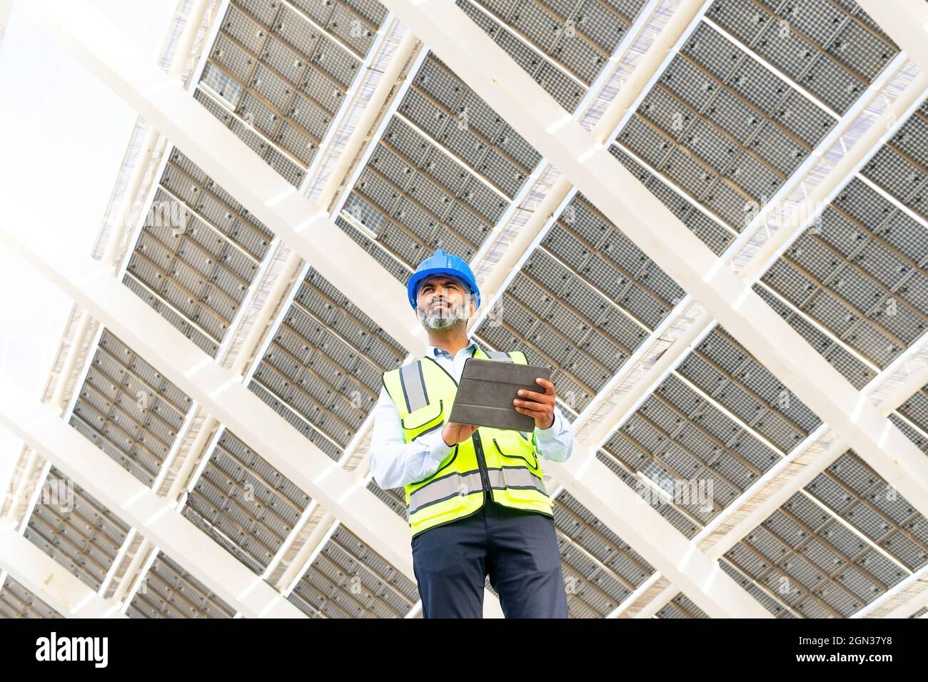 Low angle of middle aged Hispanic male engineer in uniform with tablet ...