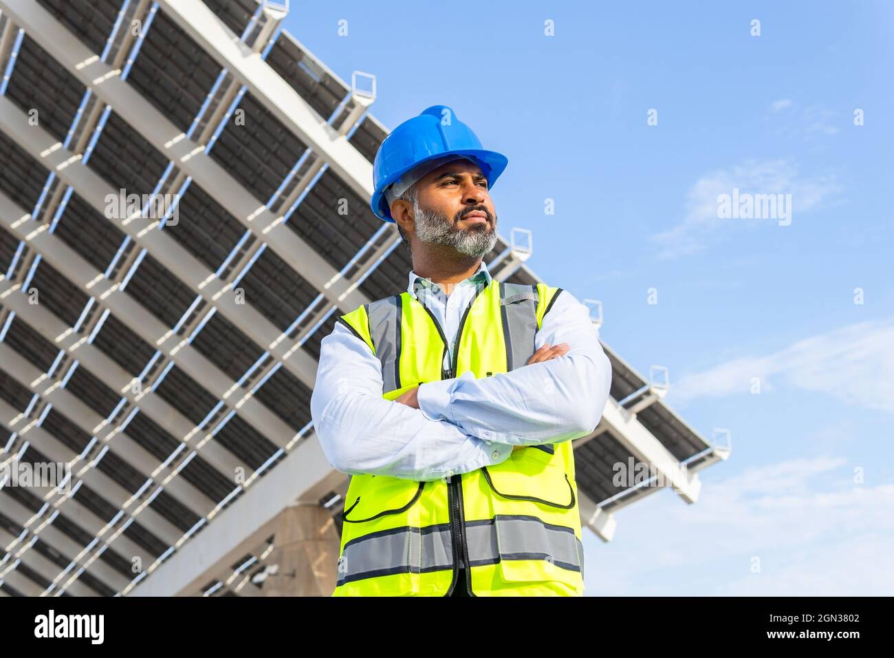 Low angle of ethnic male inspector in vest with protective helmet ...
