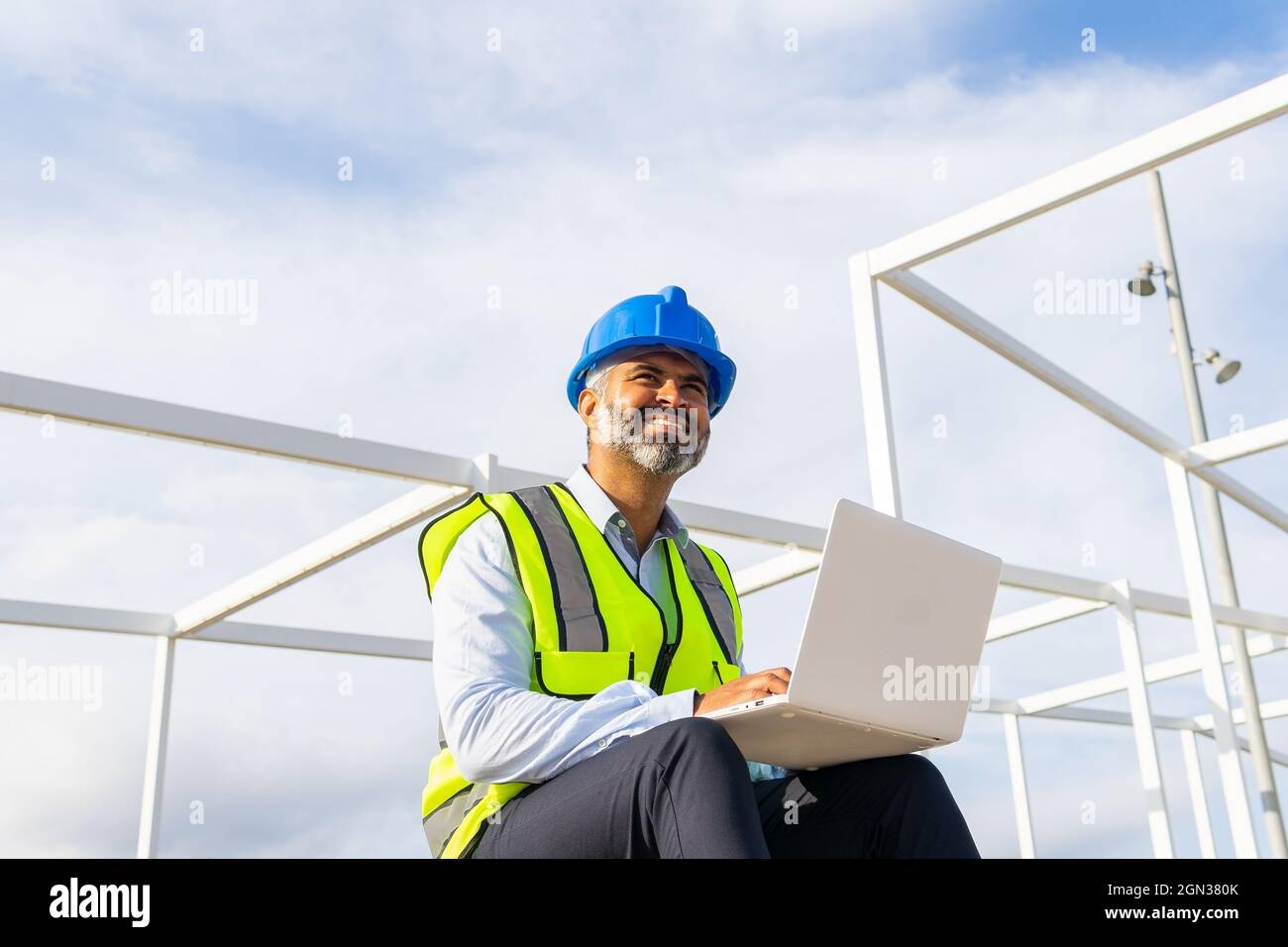 From below delighted male supervisor in uniform working on netbook ...