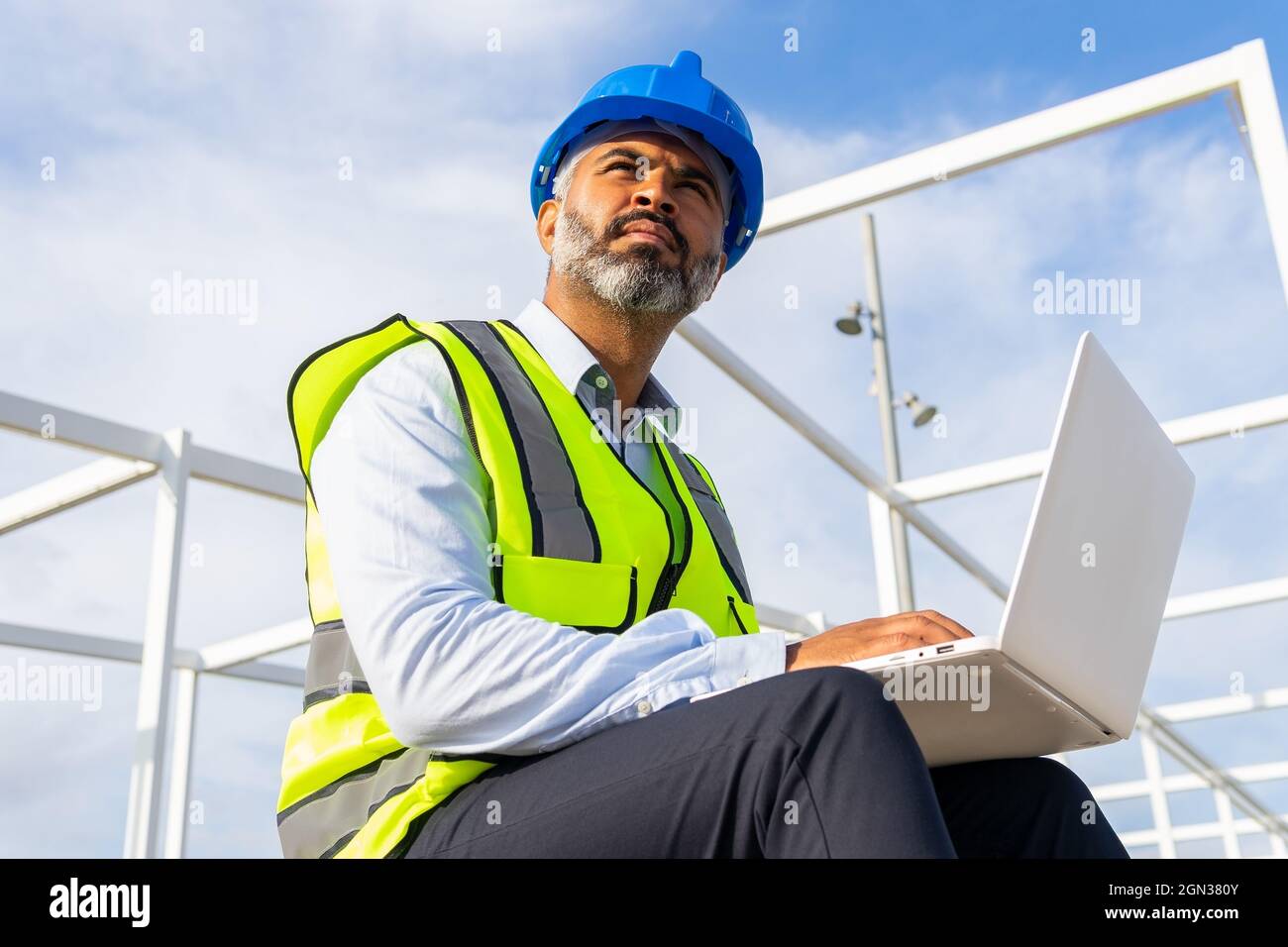From below male supervisor in uniform working on netbook sitting near ...