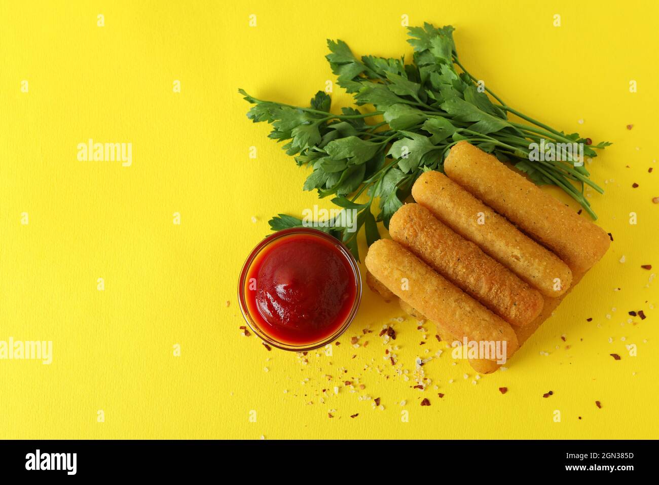 Cheese sticks, spices, ketchup and parsley on yellow background Stock ...