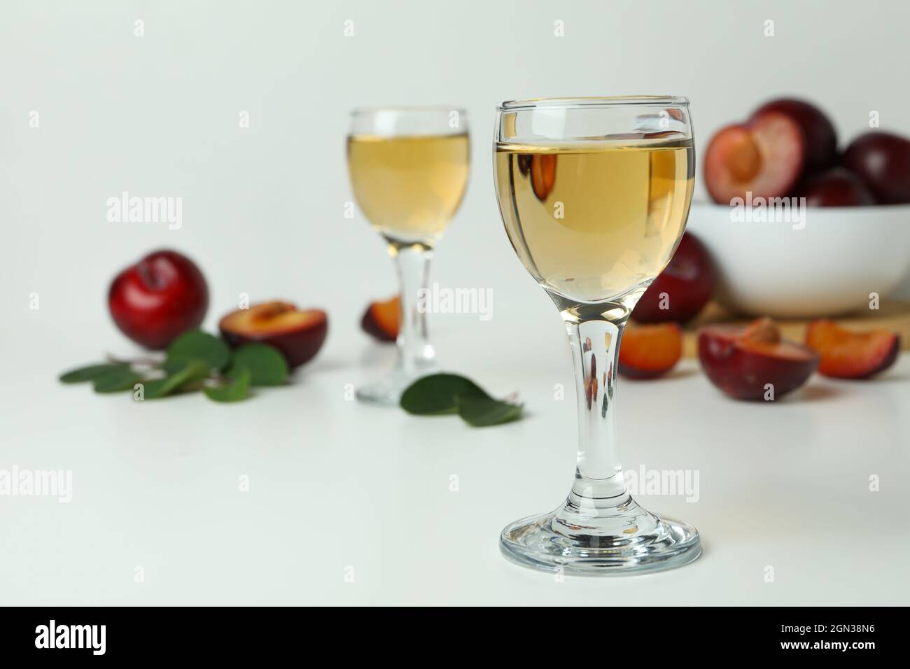 Plum vodka shots and ingredients on white background Stock Photo - Alamy