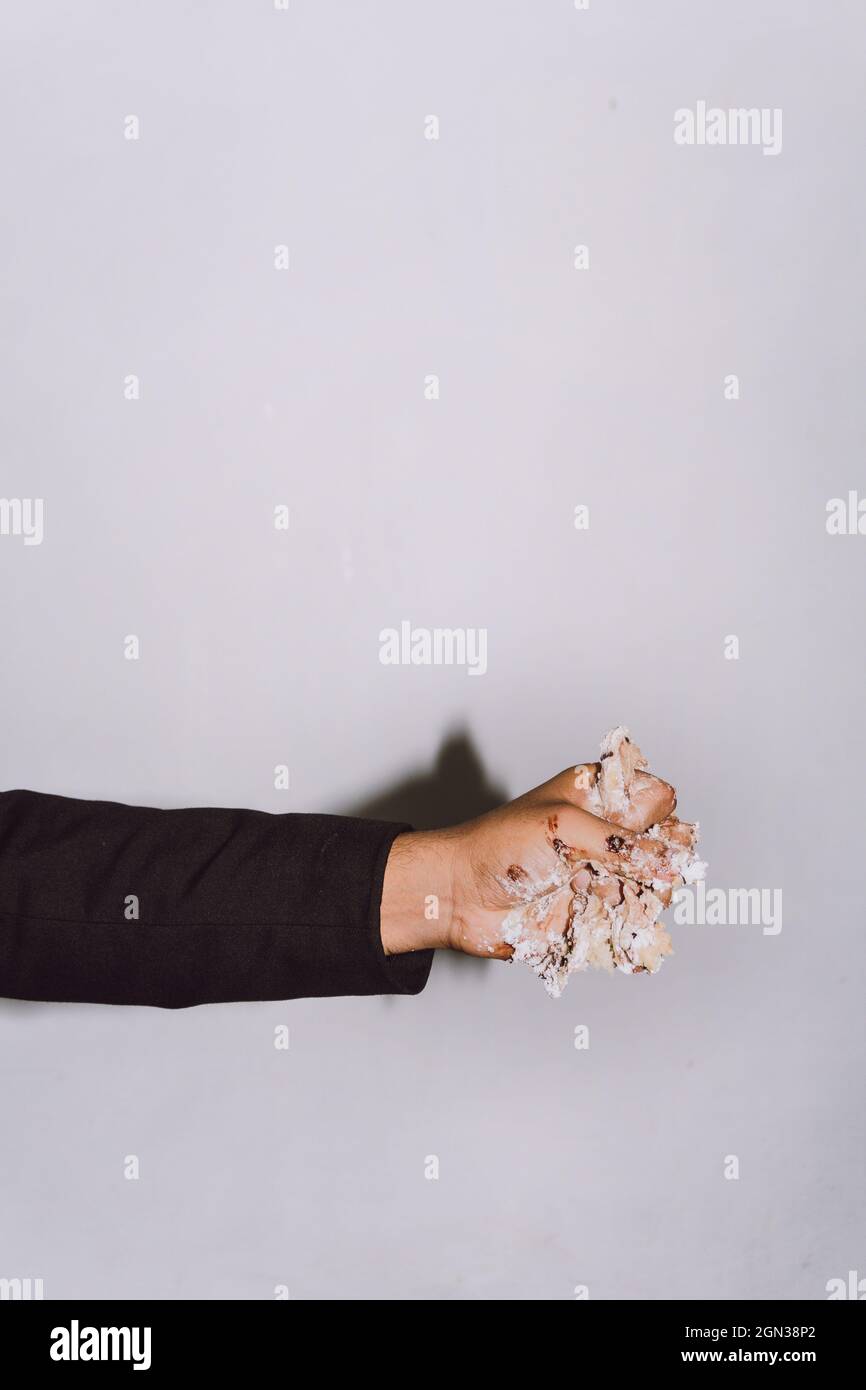 Crop anonymous male in jacket smashing sweet birthday cake during ...