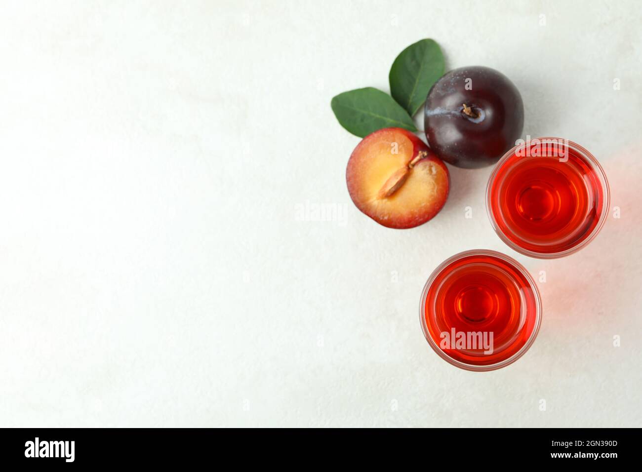 Plum brandy shots and ingredients on white textured table Stock Photo ...