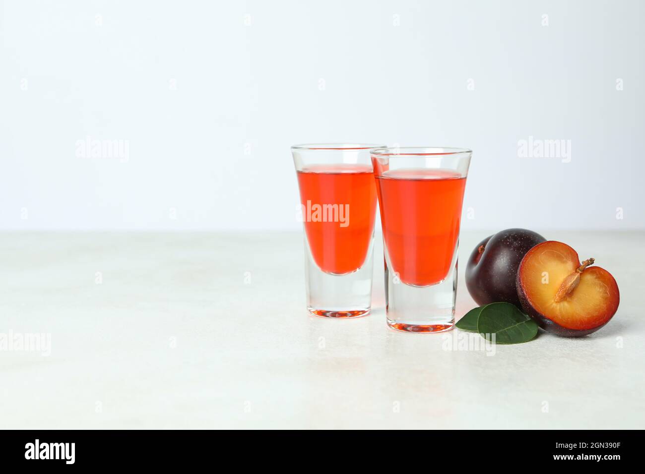 Plum brandy shots and ingredients on white textured table Stock Photo ...