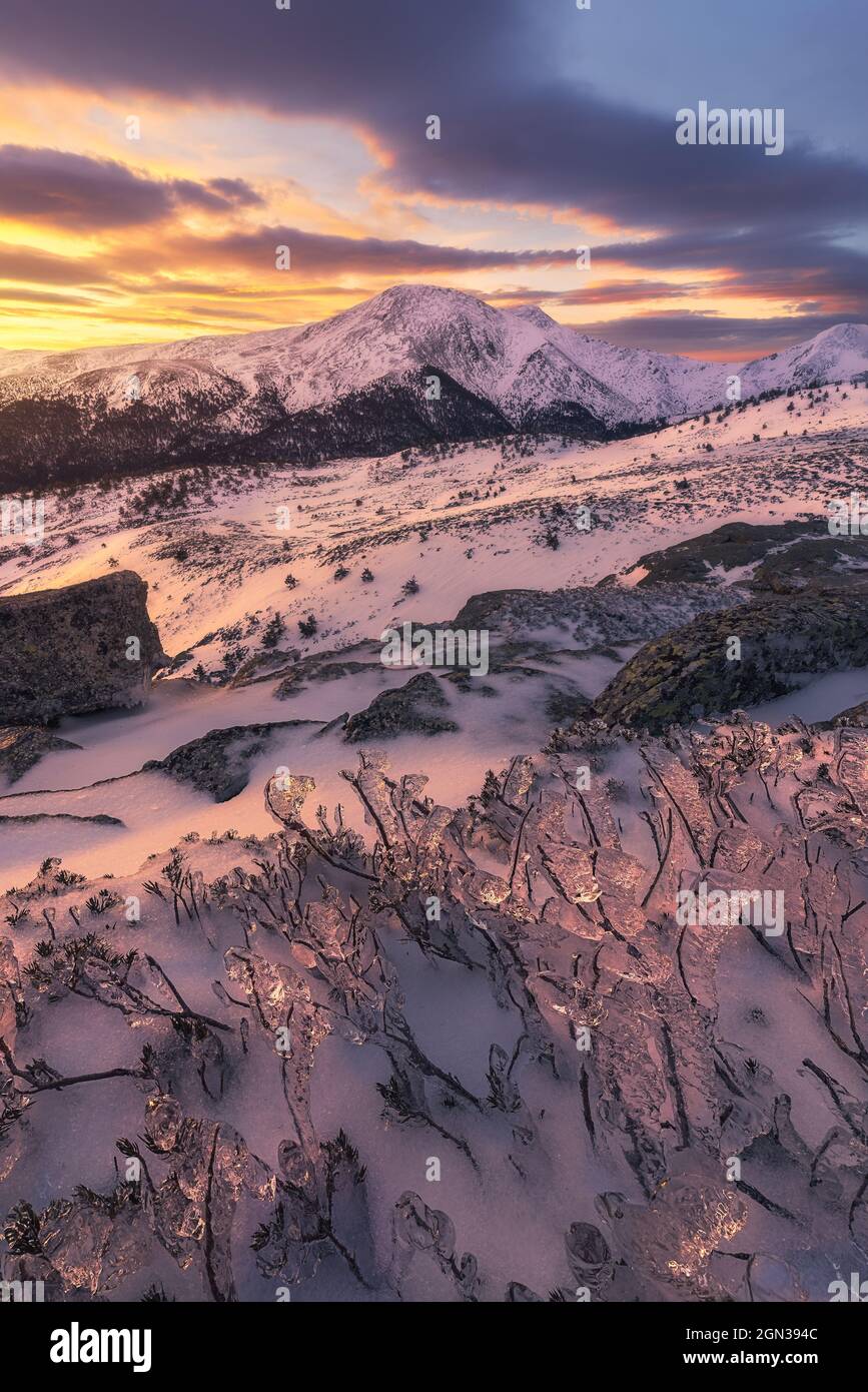 Picturesque scenery of rocky mountains covered with snow under colorful ...