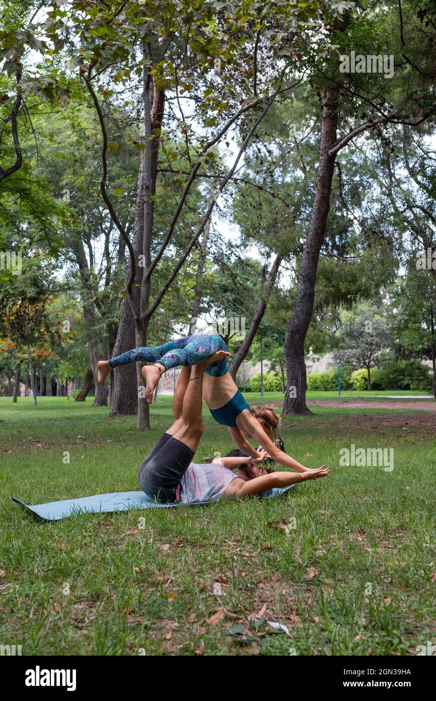 Full length of concentrate couple in activewear doing asana while ...