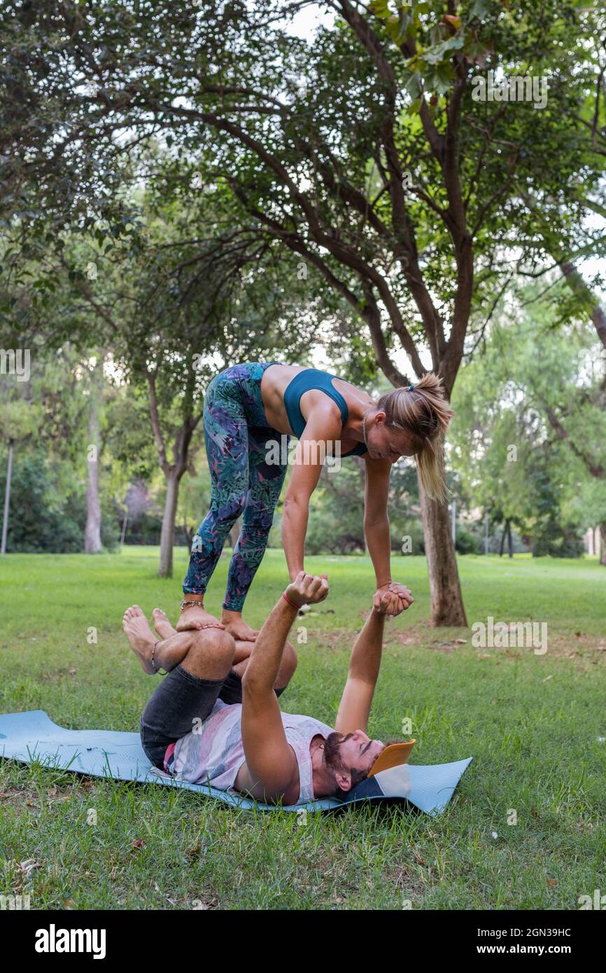 Full length of concentrate couple in activewear doing asana while ...