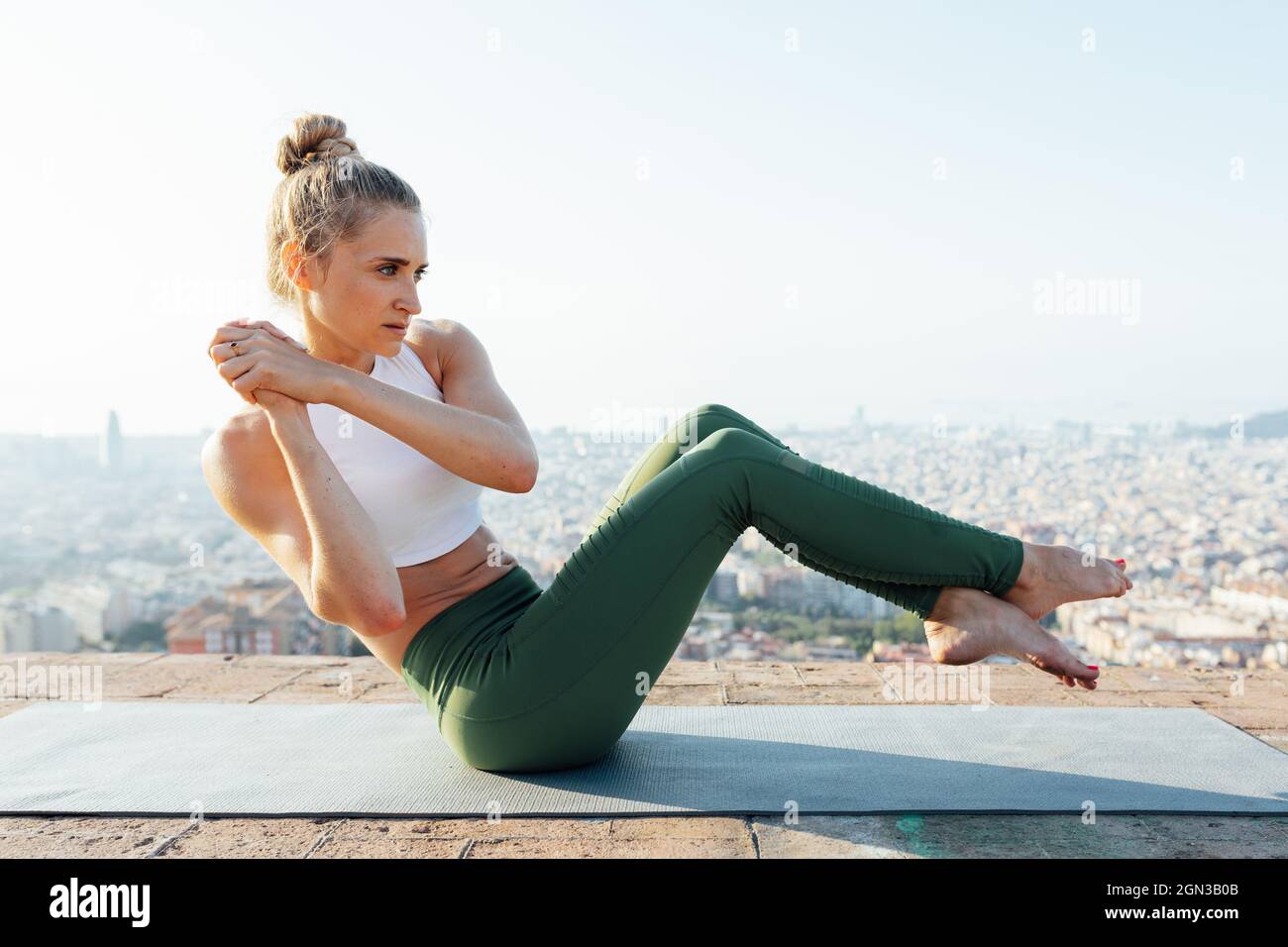 Fit female athlete in sportswear performing twist exercise with crossed ...