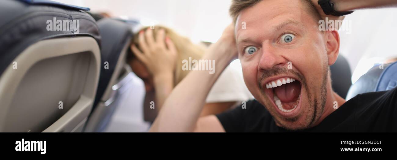 Man flying in airplane and screaming in fear Stock Photo - Alamy