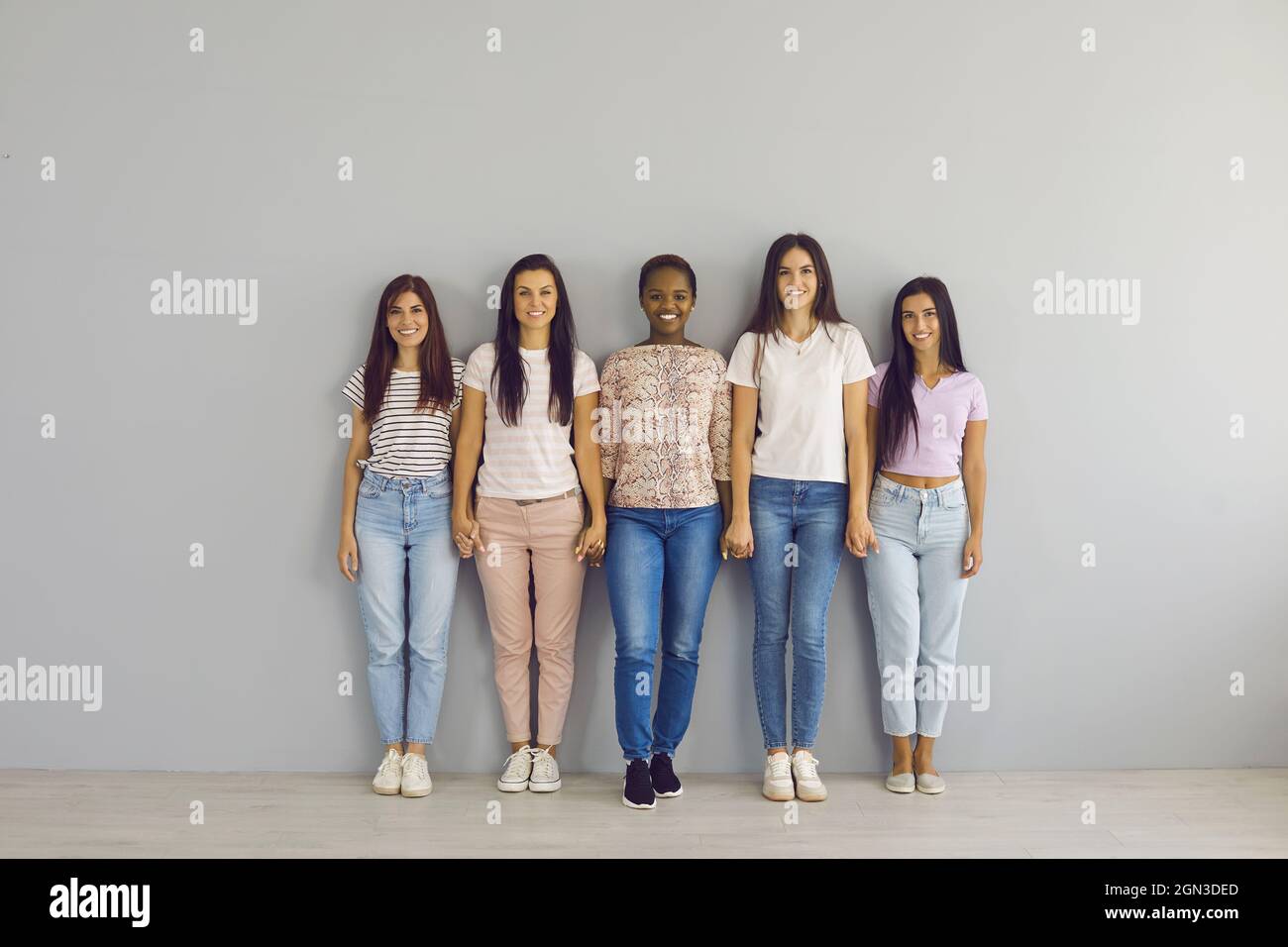 Portrait of beautiful smiling young diverse women standing in row ...